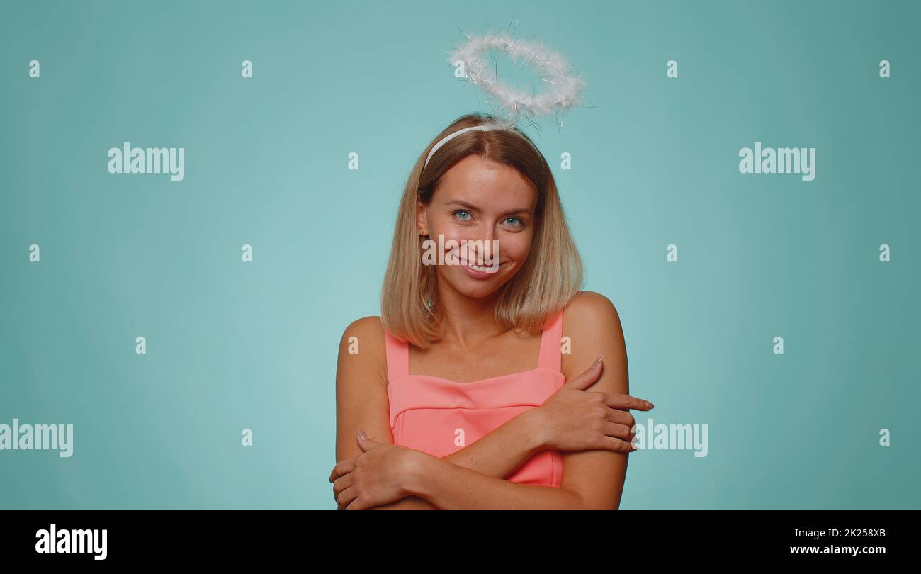 Portrait of smiling shy angelic blonde young woman with angel halo nimb ...