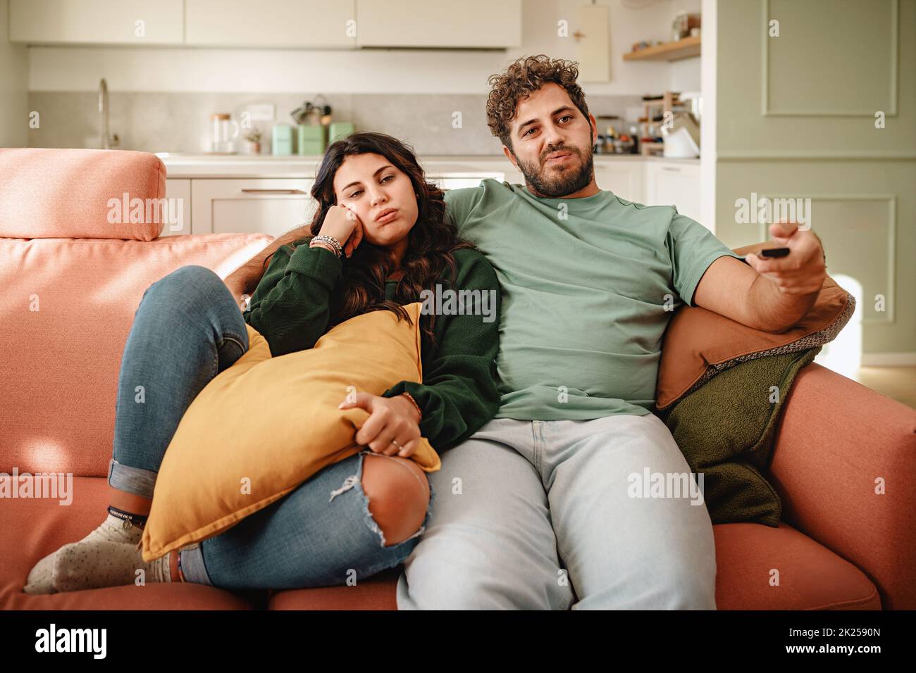 Bored Couple Watching Tv Sitting On The Sofa Newlyweds Cuddling