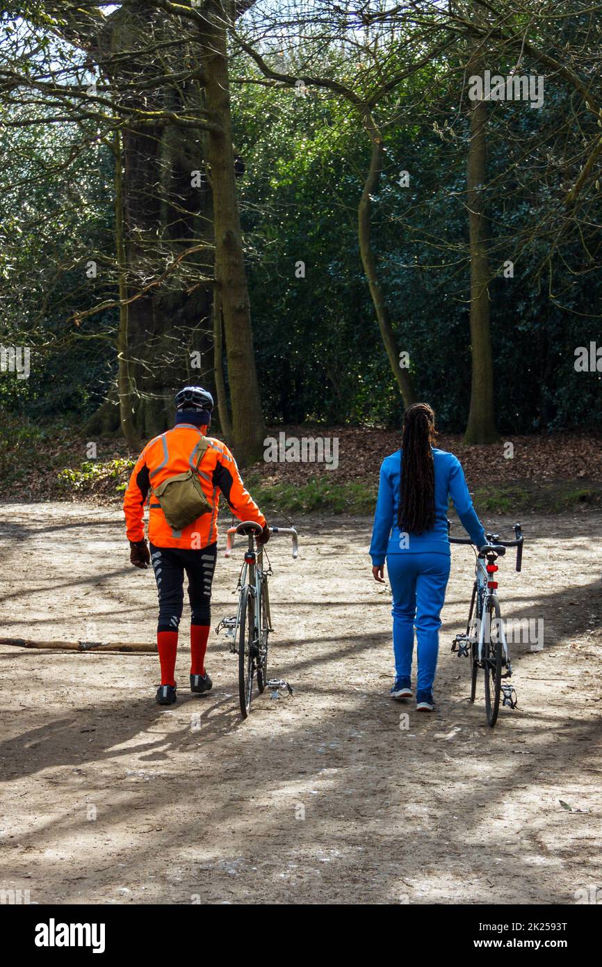 Two cyclists walking their bikes along a woodland path Stock Photo - Alamy