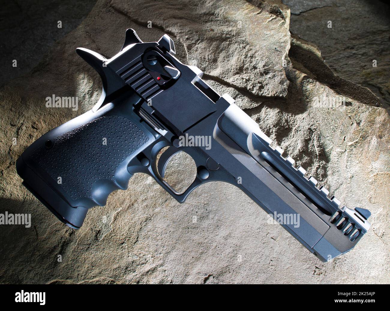 Semi-automatic pistol that is on a bunch of beige rocks Stock Photo - Alamy