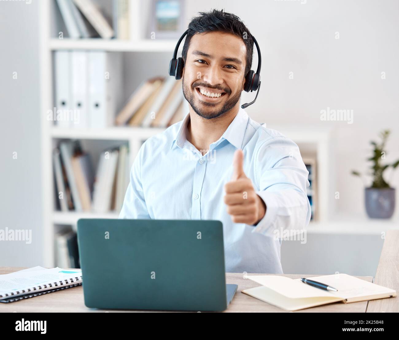 Thumbs up, customer service and call center with a man saying yes while ...