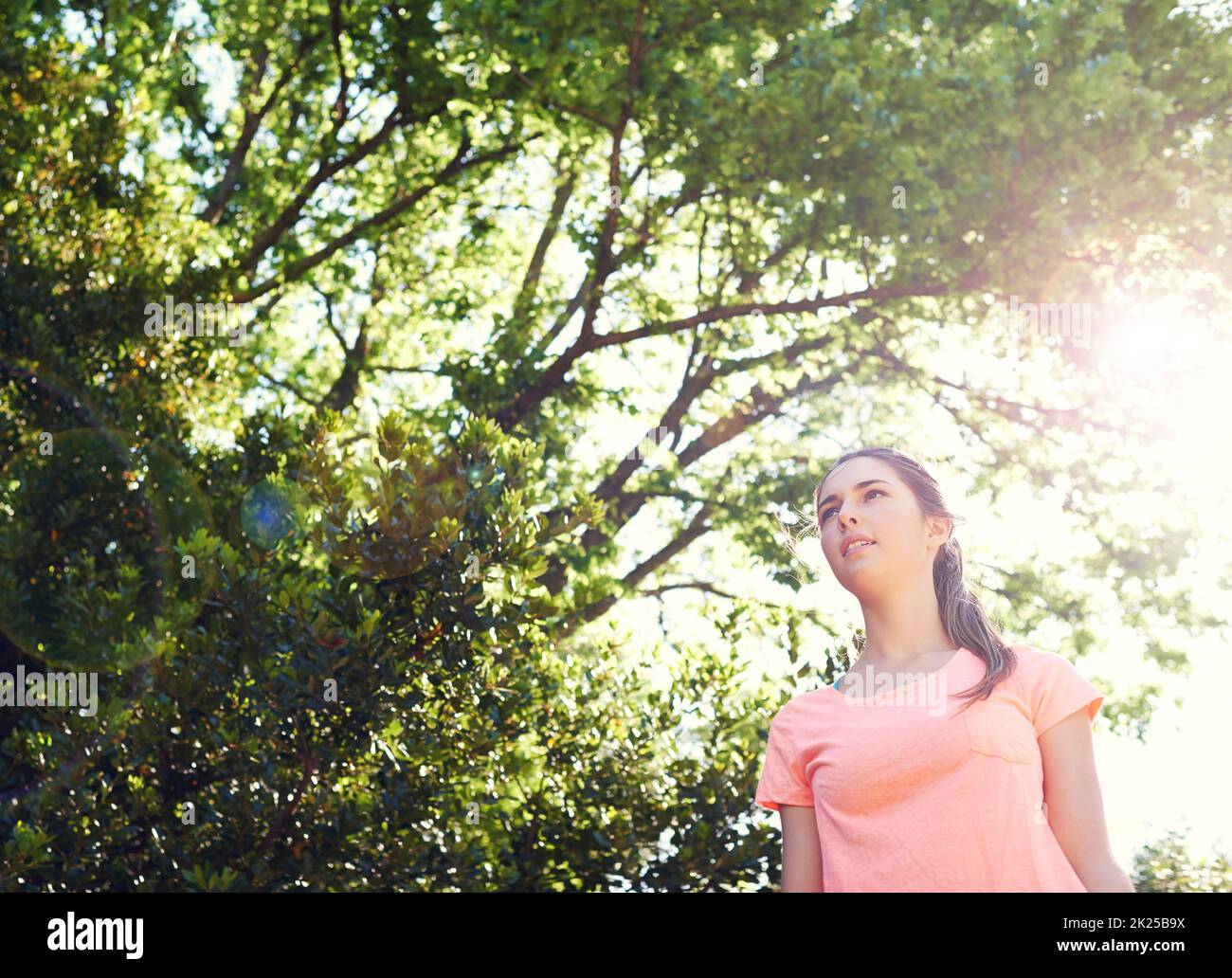 Enjoying a walk through nature. a sporty young woman walking beside ...