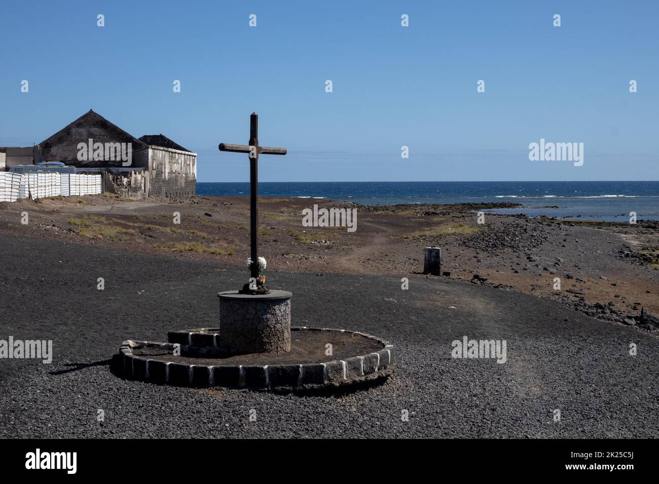 Cross at the coast of Atlantic ocean. Abandoned buidling without a roof ...