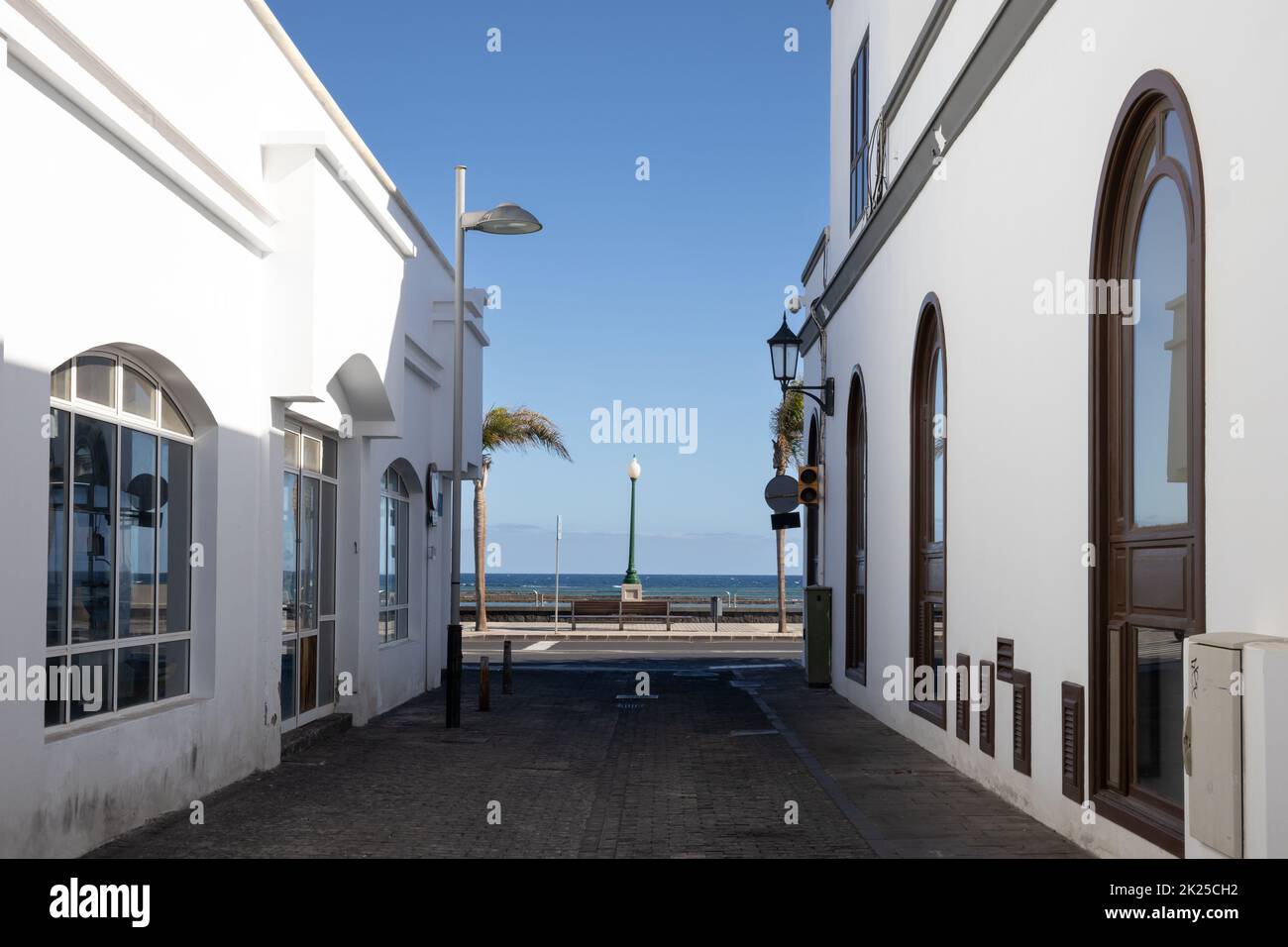 Traditional white architecture. Street between houses with an arched ...