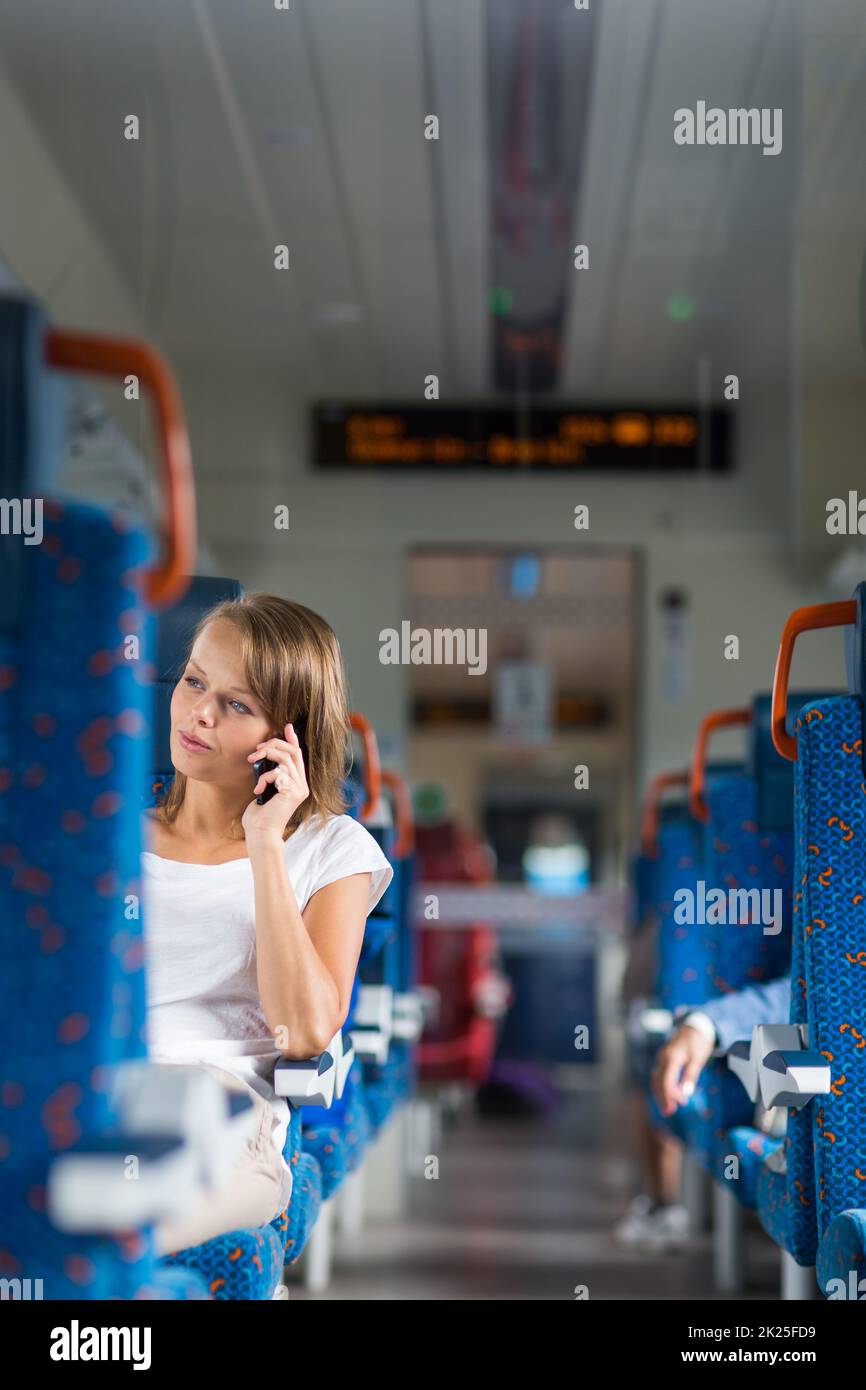 Pretty young woman boarding a train/having arrived to her destination ...