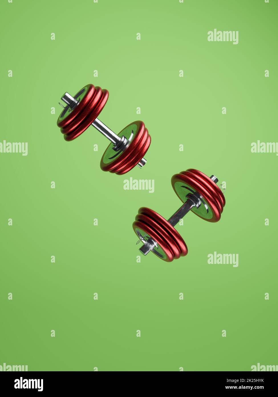 Two red metal dumbbells on a green background Stock Photo - Alamy