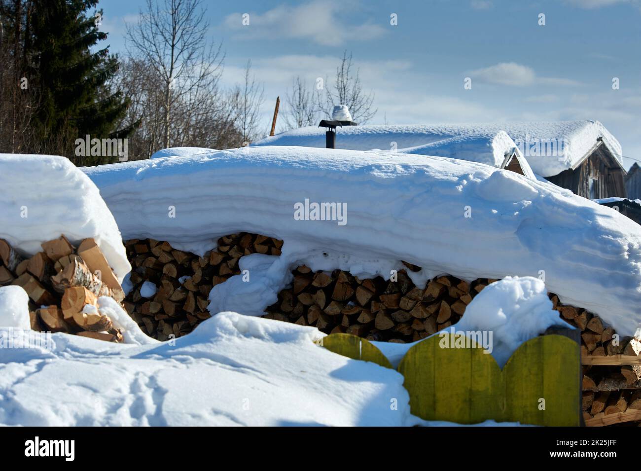Wood piled in a woodpile under the snow in winter Stock Photo - Alamy