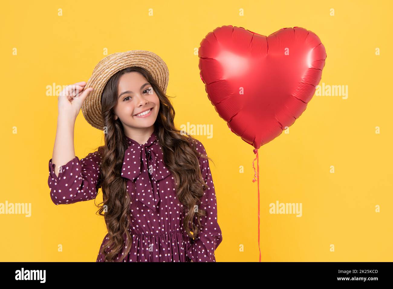 smiling teen girl with red heart balloon on yellow background Stock ...