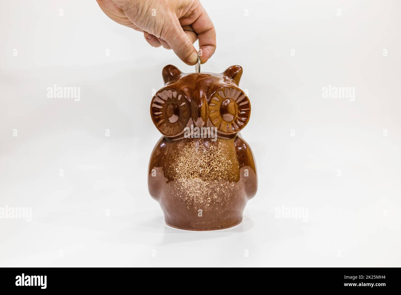 human hand putting coin In money box on white background Stock Photo ...