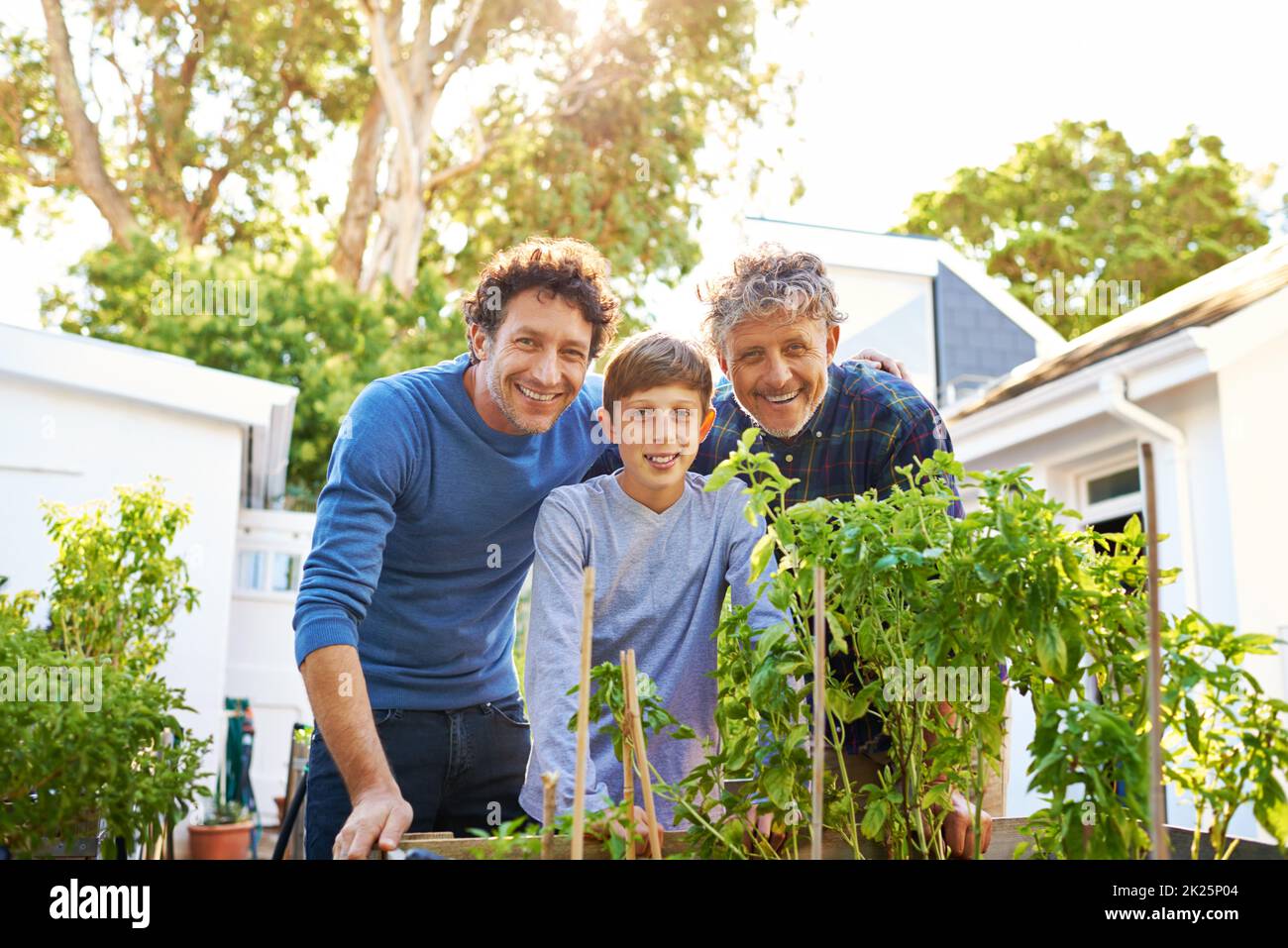 Three generations of gardeners. Portrait of a young boy gardening with ...
