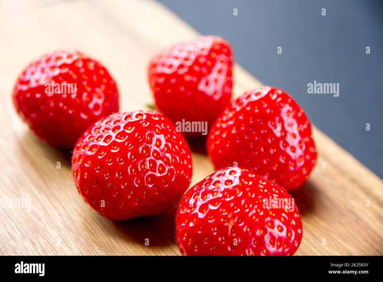 Strawberries on a cutting board. Black background Stock Photo - Alamy