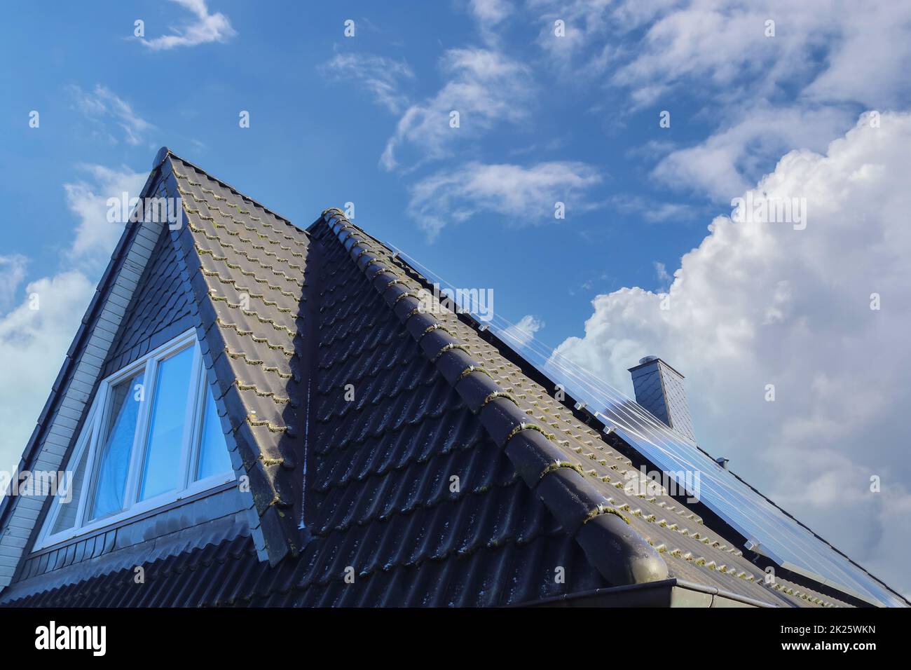 Open roof window in velux style with black roof tiles Stock Photo - Alamy