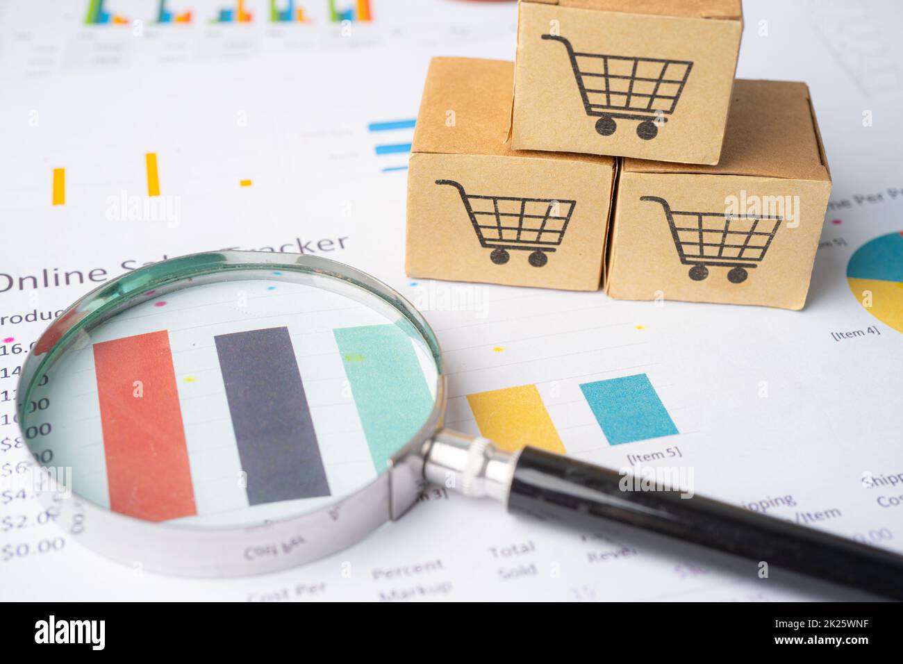 Shopping cart logo on box with magnifying glass on graph background ...