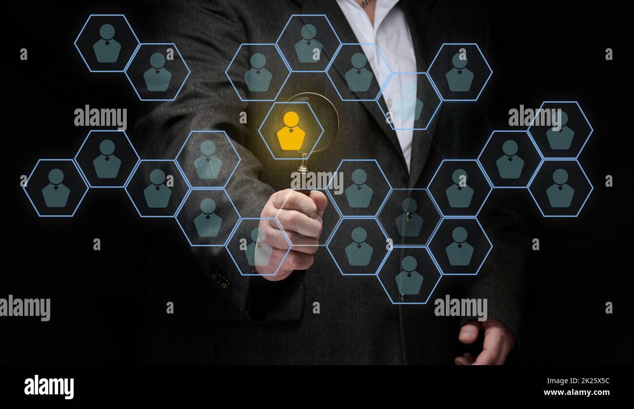 A businessman holds in his hand a magnifying glass and an interactive ...