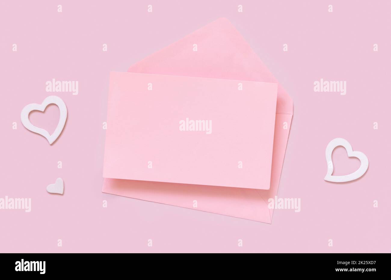 Pink paper card and envelope and hearts on pink top view, card mockup ...