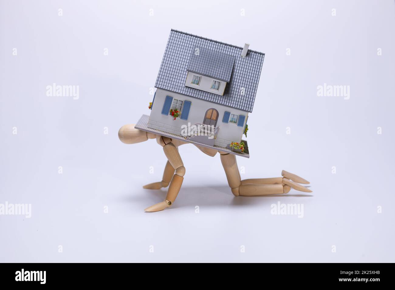 A figure carries the burden of a house Stock Photo - Alamy