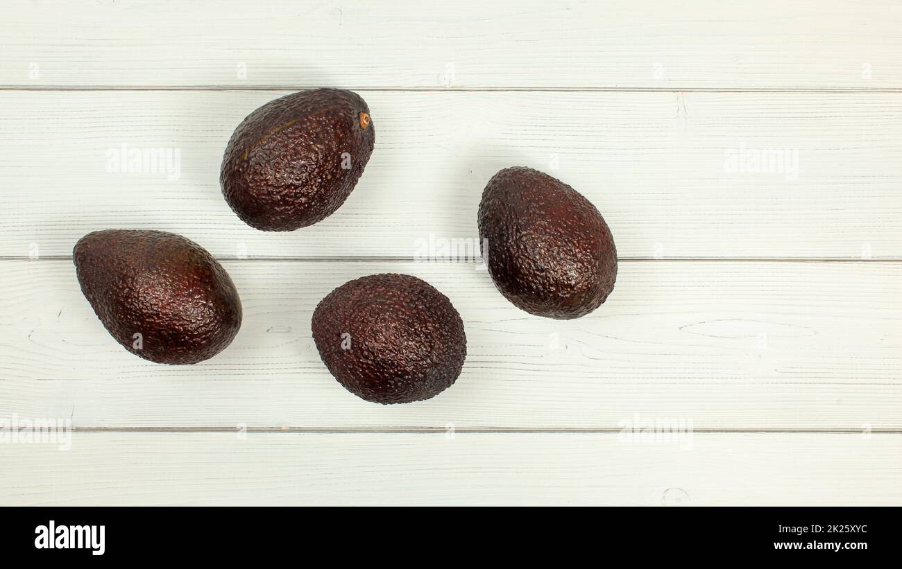 Four ripe brown avocados on white boards desk. Tabletop view Stock ...