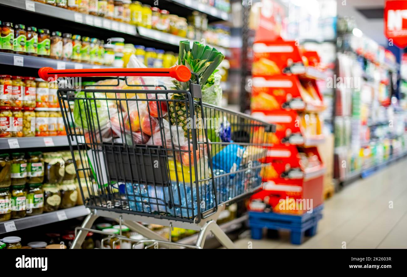 A shopping cart with grocery products in a supermarket Stock Photo - Alamy