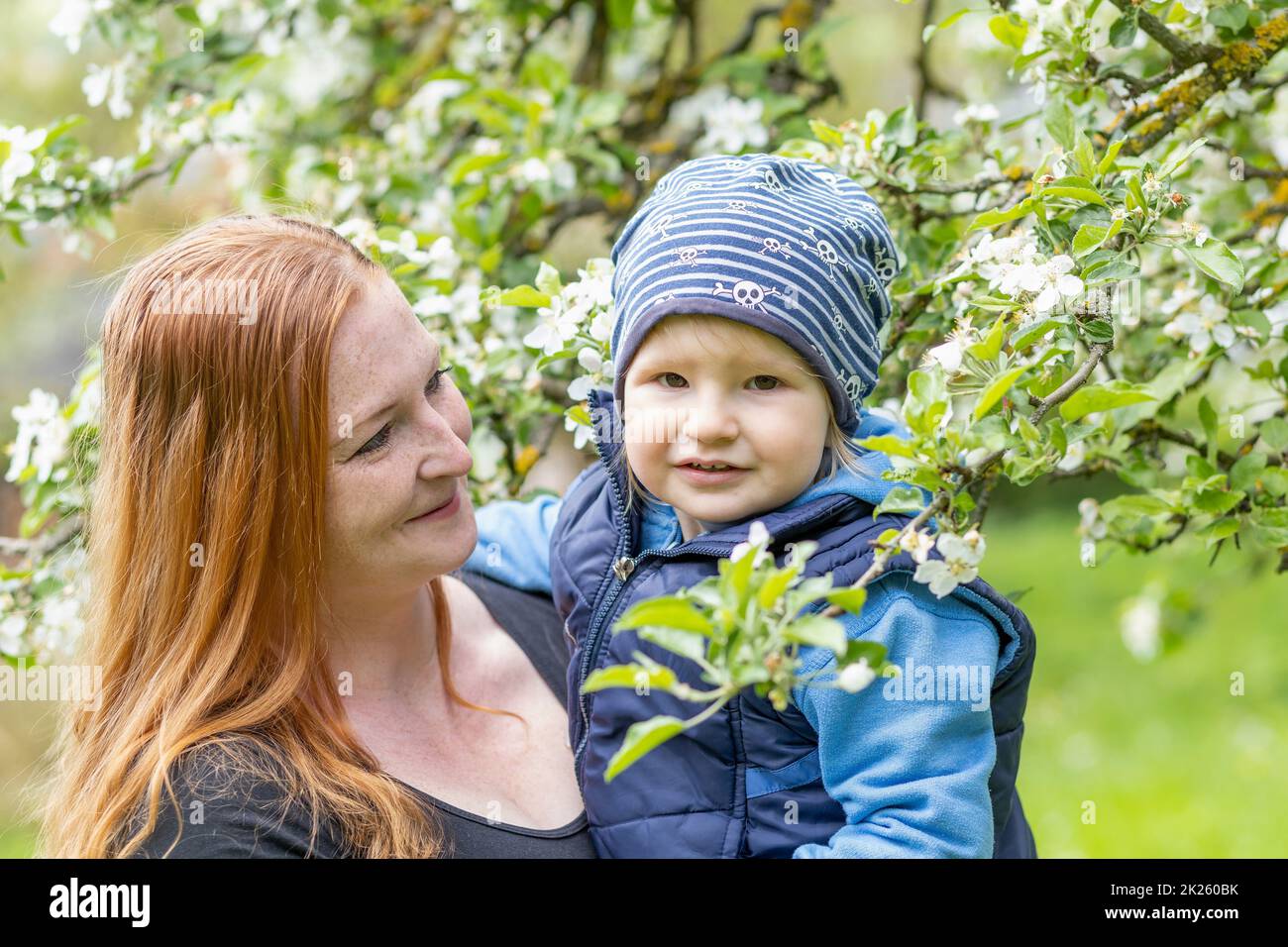 Young mother is holding her little son in her arms oudoors Stock Photo - Alamy