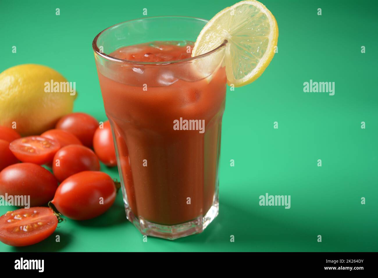 Full glass of fresh tomato juice with cherry tomatoes around . Very ...