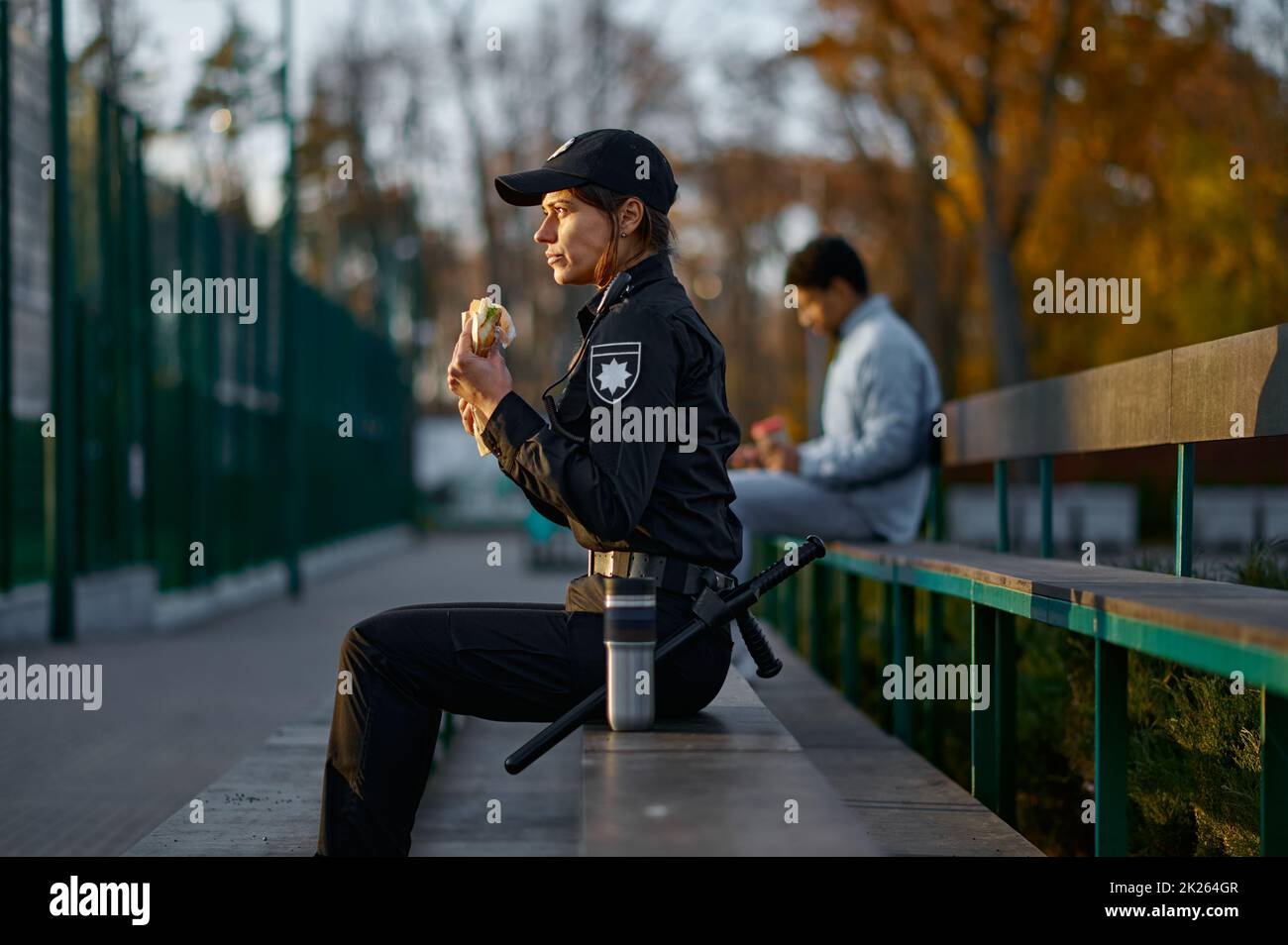Police woman take break eating in park Stock Photo - Alamy
