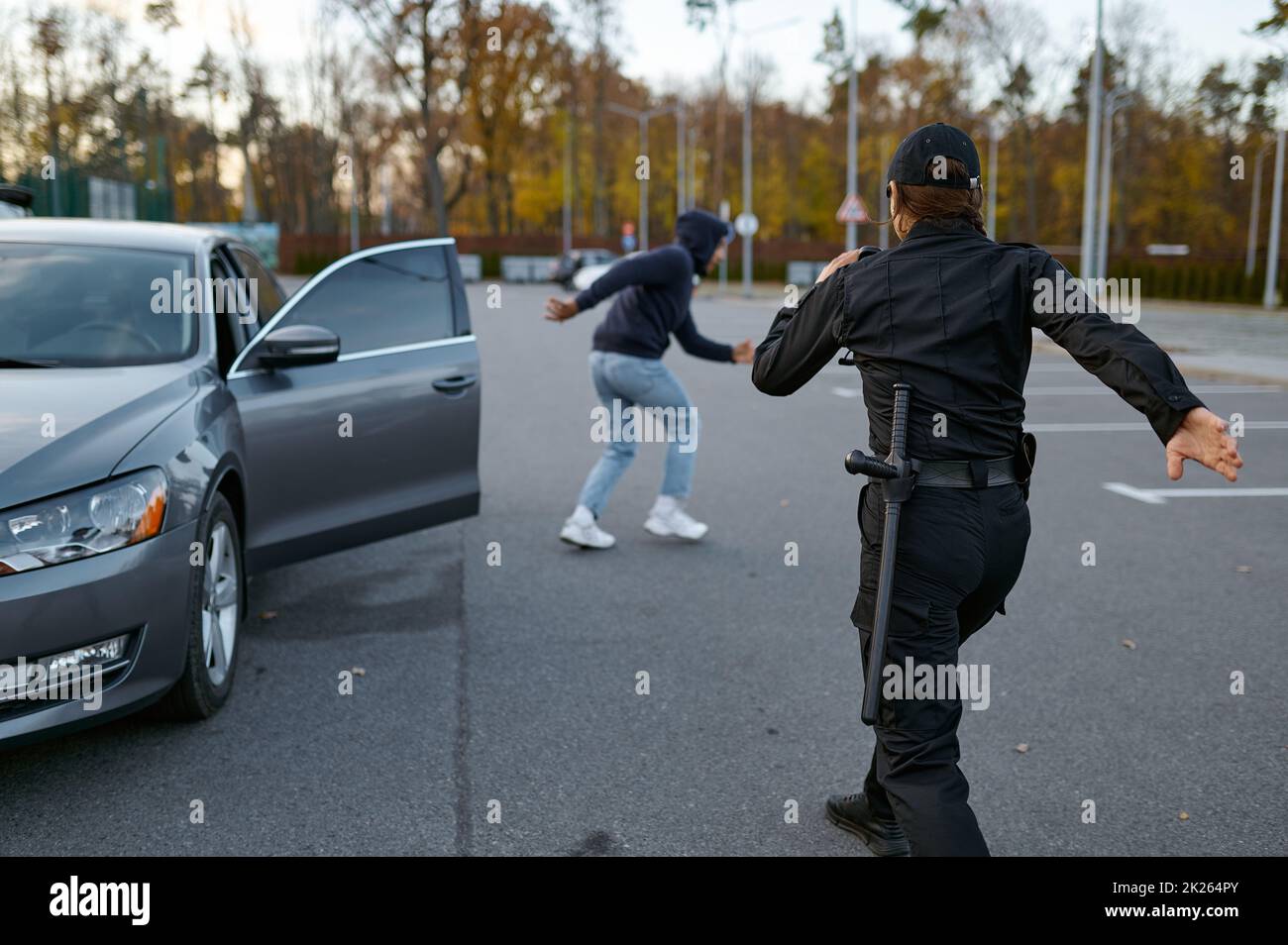Woman cop running after hooded car thief Stock Photo - Alamy
