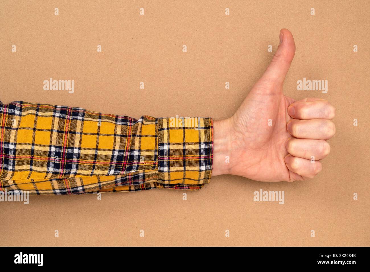 Hand with thumb upwards on a brown paper background Stock Photo - Alamy