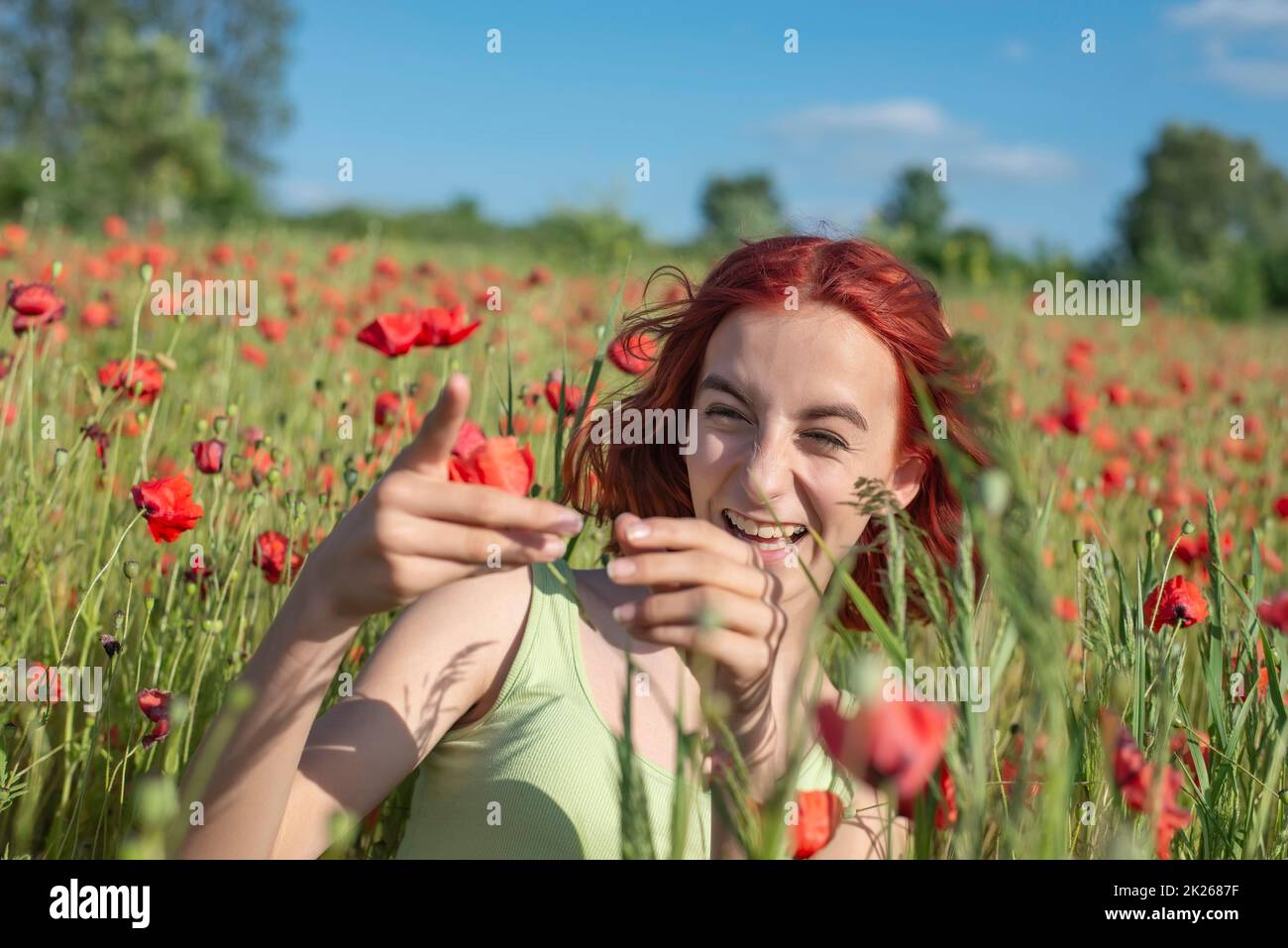 happy young girl with red hairs in poppy field Stock Photo - Alamy