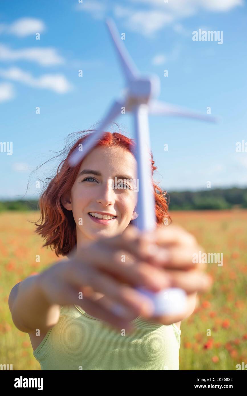 girl with wind turbine in poppy field Stock Photo - Alamy