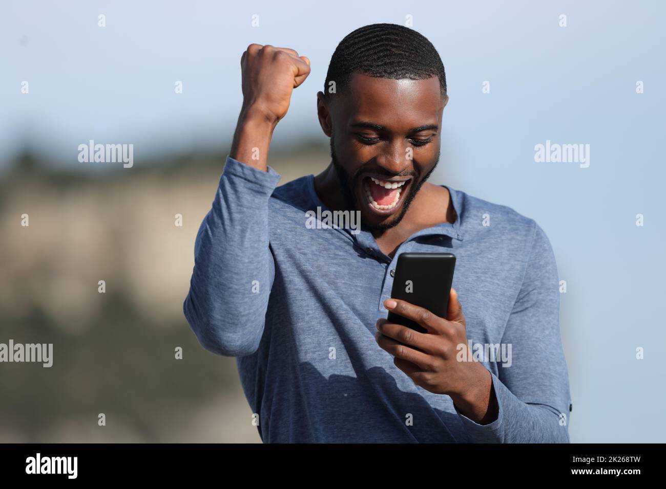 African man celebrating success using hi-res stock photography and ...