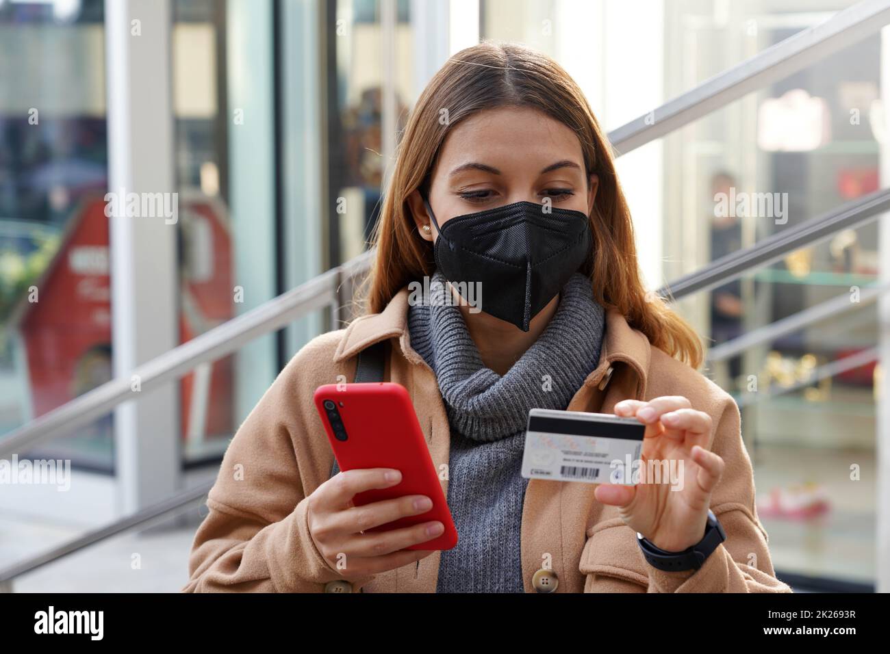 Credit card payment outdoors. Beautiful young woman with black ...