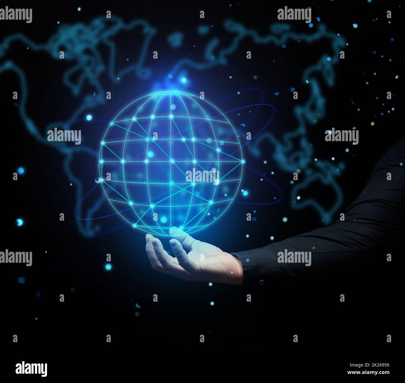 a man's hand holds a holographic globe on a dark blue background ...