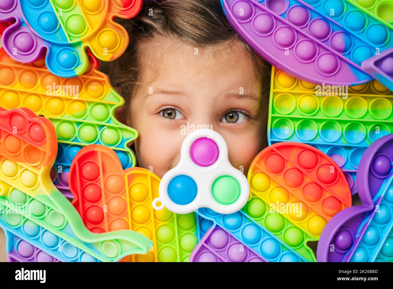 Little girl,kid,child head among many,lots of colorful pop it. Children ...