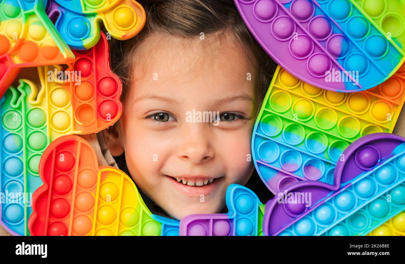 Little girl,kid,child head among many,lots of colorful pop it. Children ...
