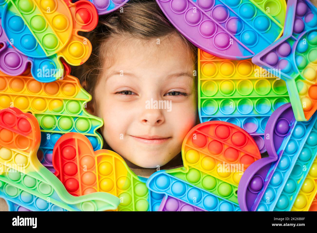 Little girl,kid,child head among many,lots of colorful pop it. Children ...
