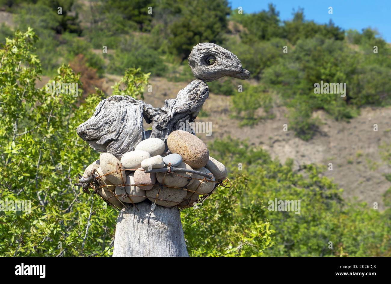 A sculpture made of stones and wood in the form of a bird in a nest ...