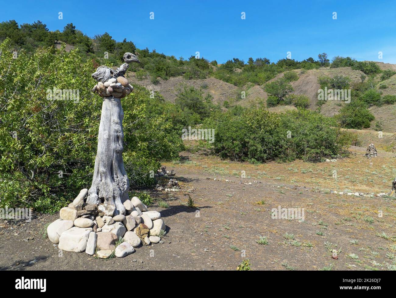 A sculpture made of stones and wood in the form of a bird in a nest ...