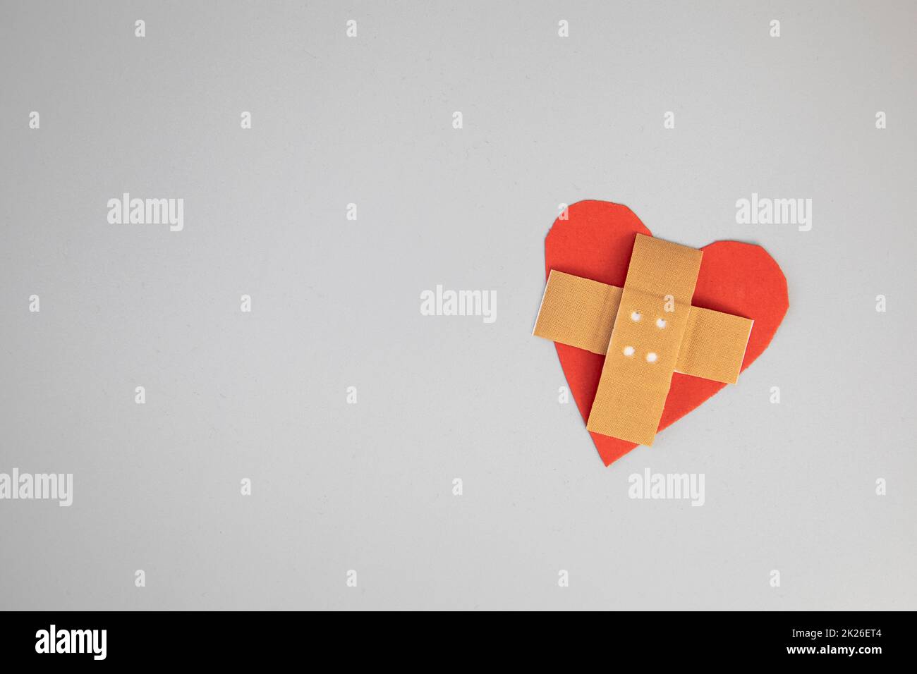 Heart with medical patch on grey background, top view. Relationship ...