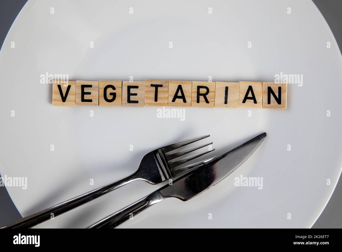 Top view white plate with vegetarian word against grey background top ...