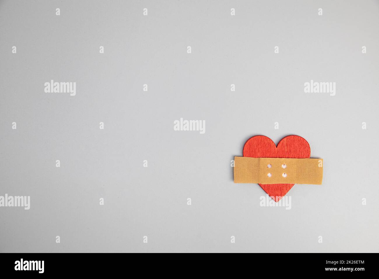Heart with medical patch on grey background, top view. Relationship ...