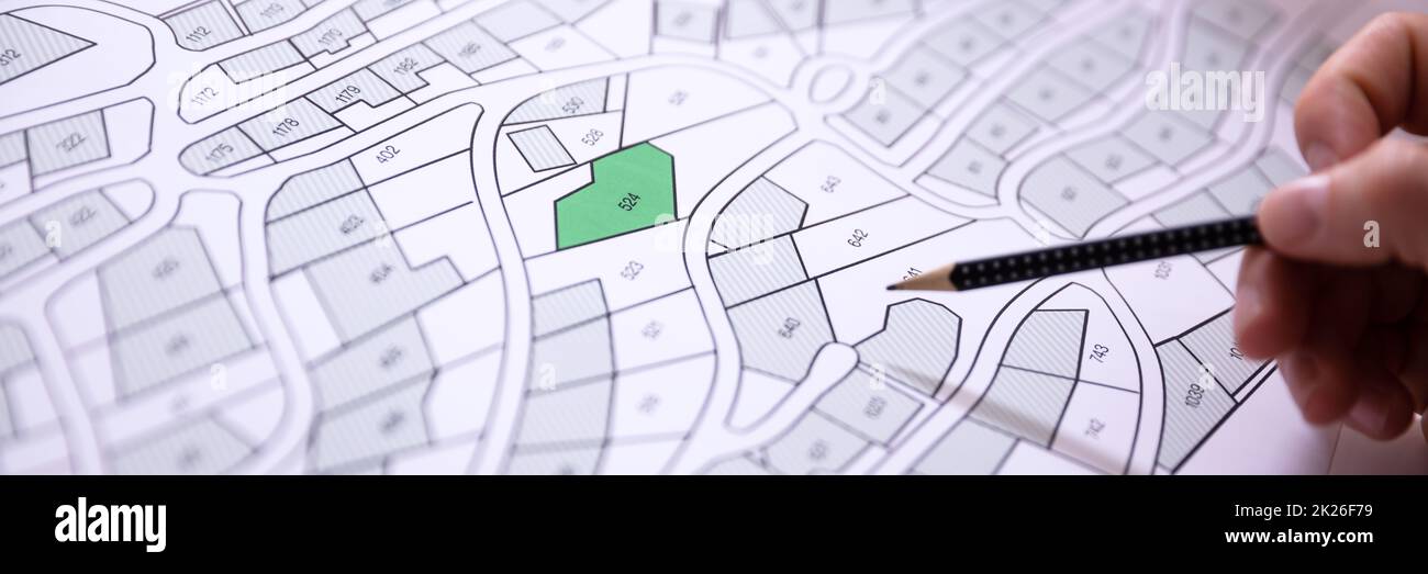Human Hand Holding Pencil Over Cadastre Map Stock Photo - Alamy