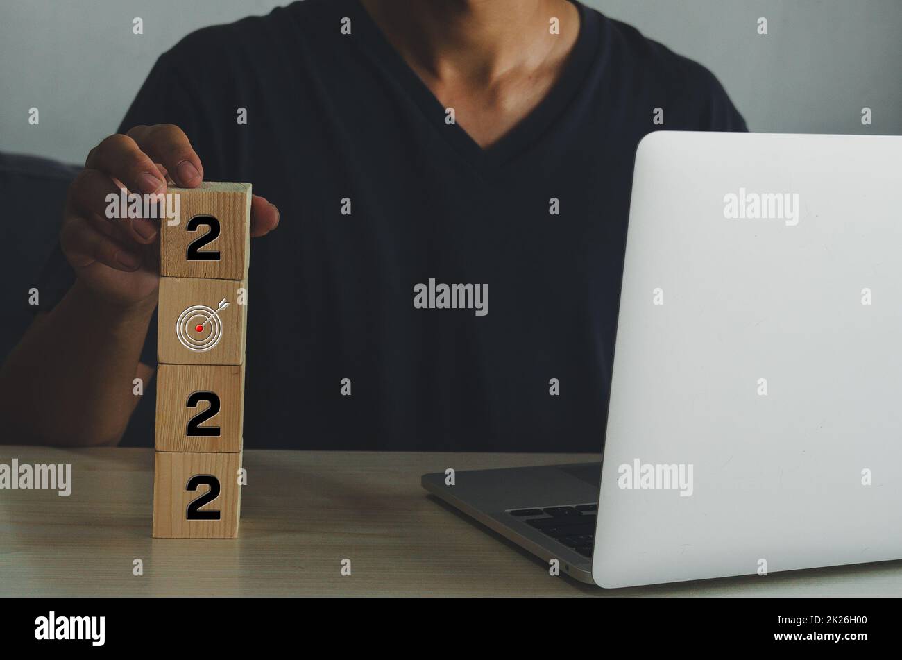 Man holding cube wooden target numeber 2022 Working on a desk with a ...