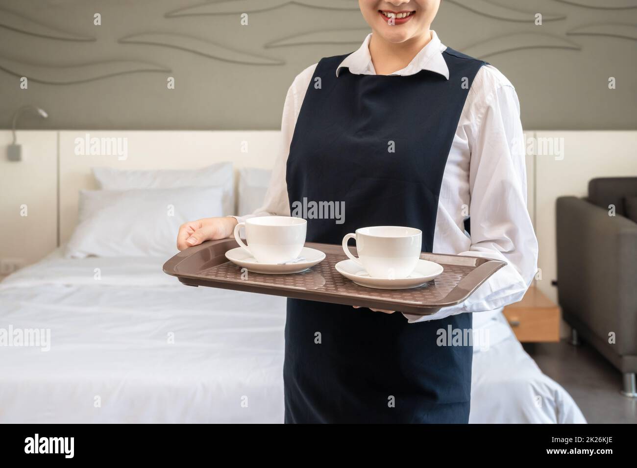Smiling Chambermaid holding tray with cups of coffee. Hotel room ...