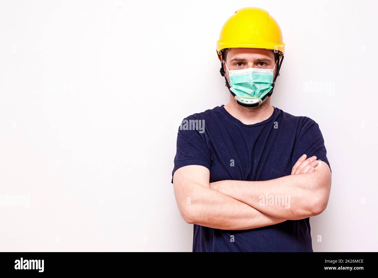Constraction worker behind white background. Wearing green mask and ...