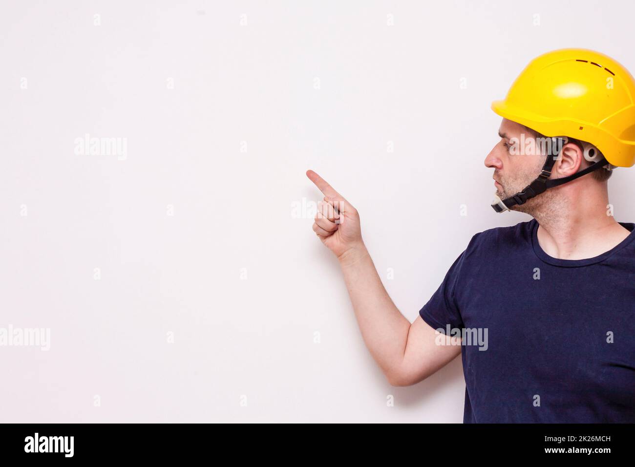 Constraction worker behind white background. Wearing green mask and ...