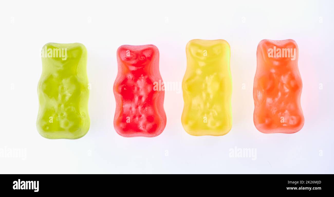 green, red, yellow and orange colored gummy bears in a row side by side ...