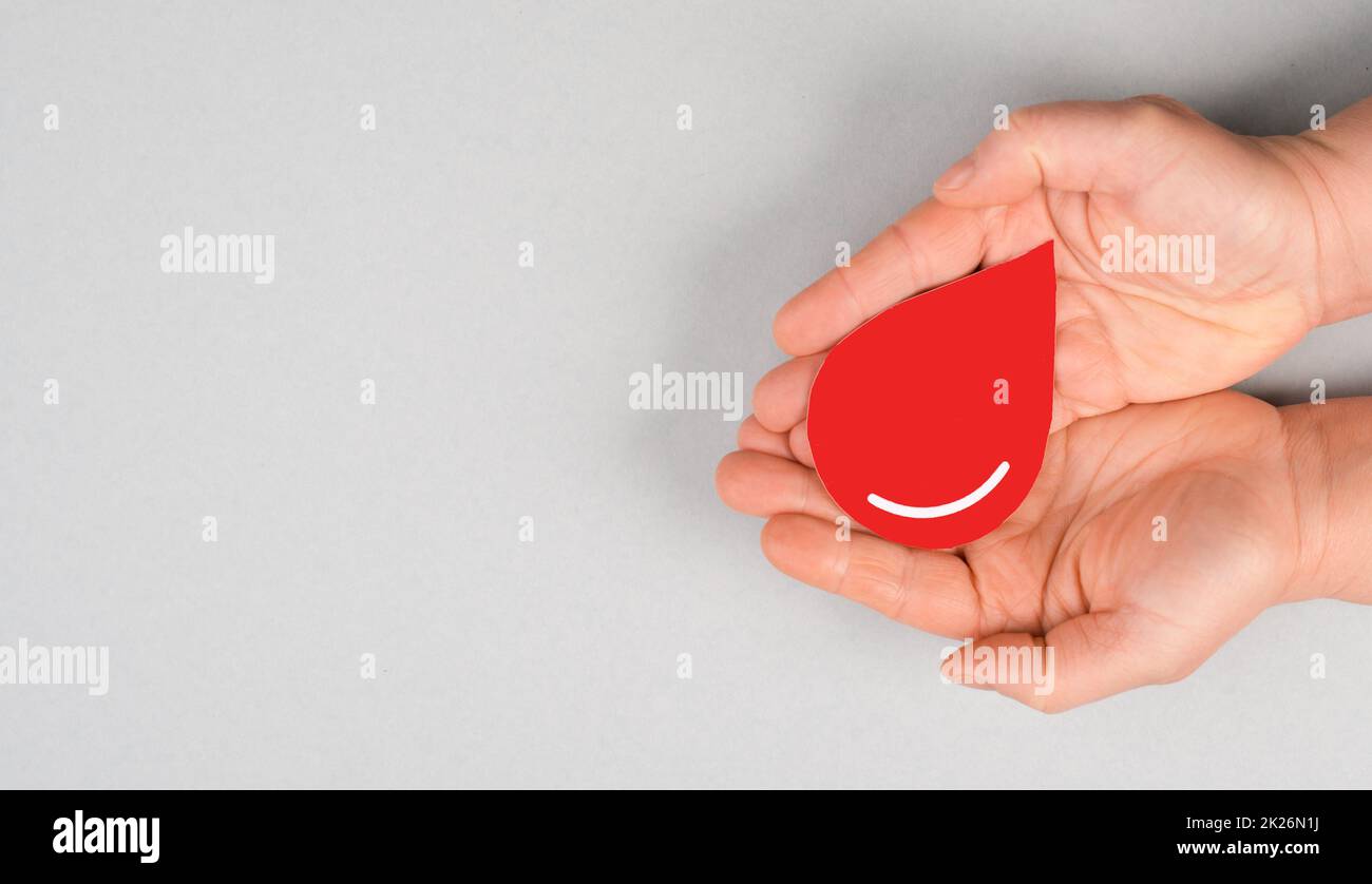 Holding a red drop in the hands, donate blood, world blood donor day ...
