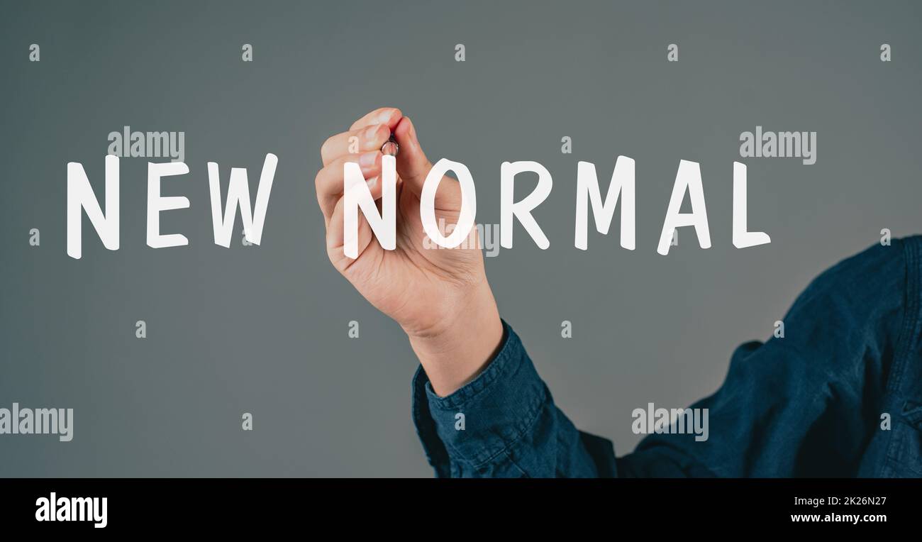 Young man writes the words new normal, post covid-19 pandemic, changing ...