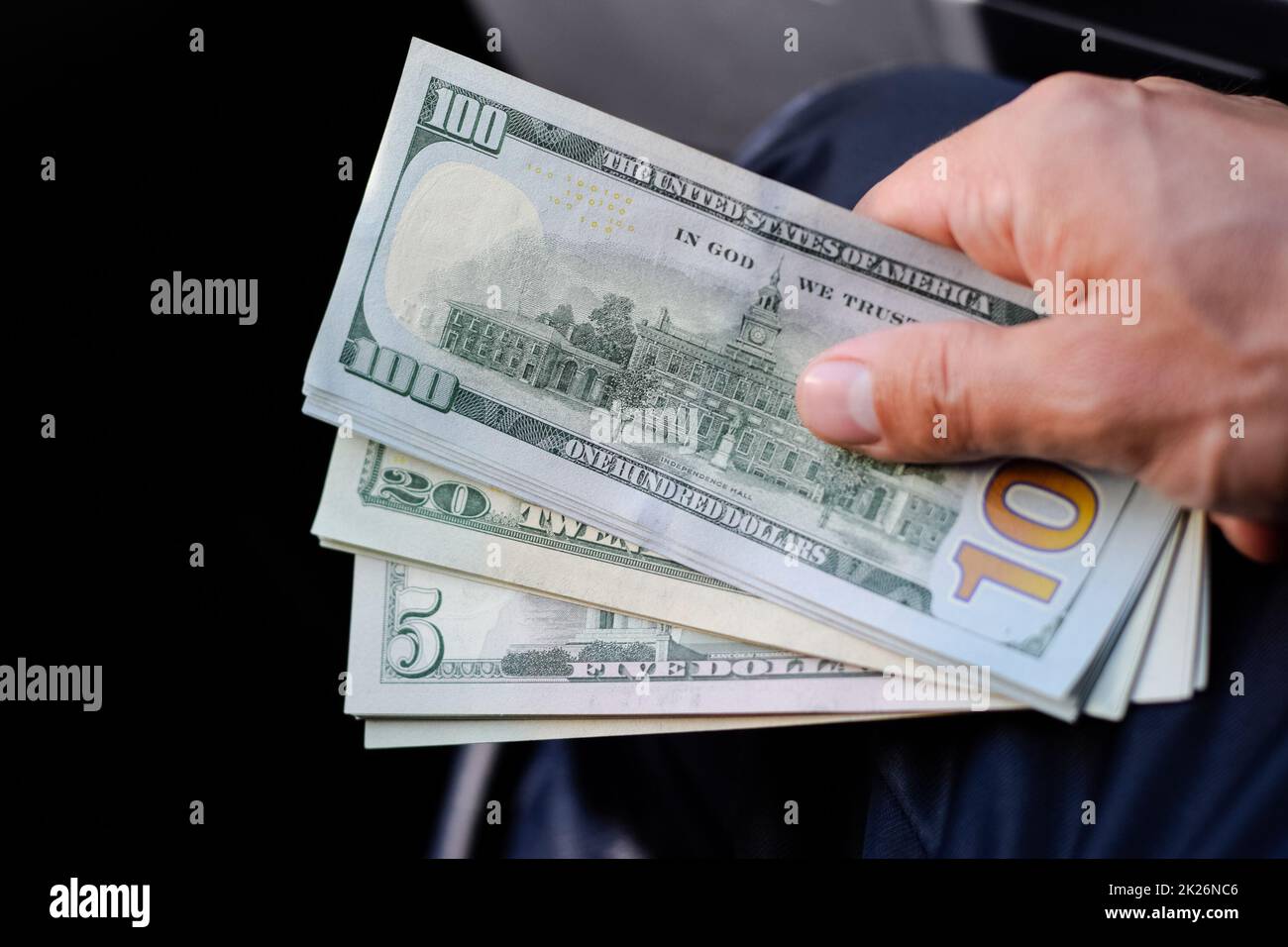 man hands over money in a car. A wad of dollars in his hand Stock Photo ...