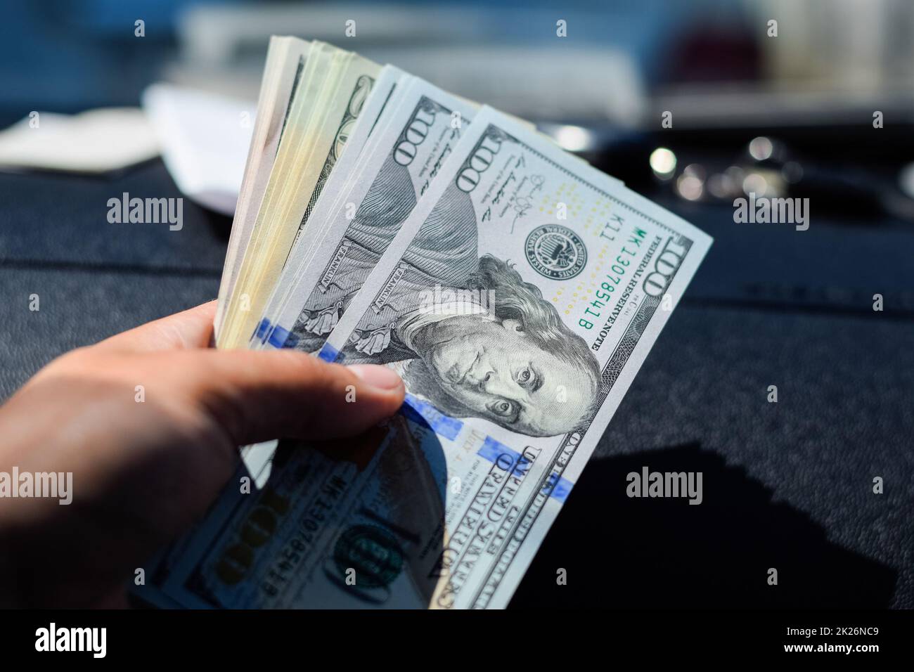 man hands over money in a car. A wad of dollars in his hand Stock Photo ...